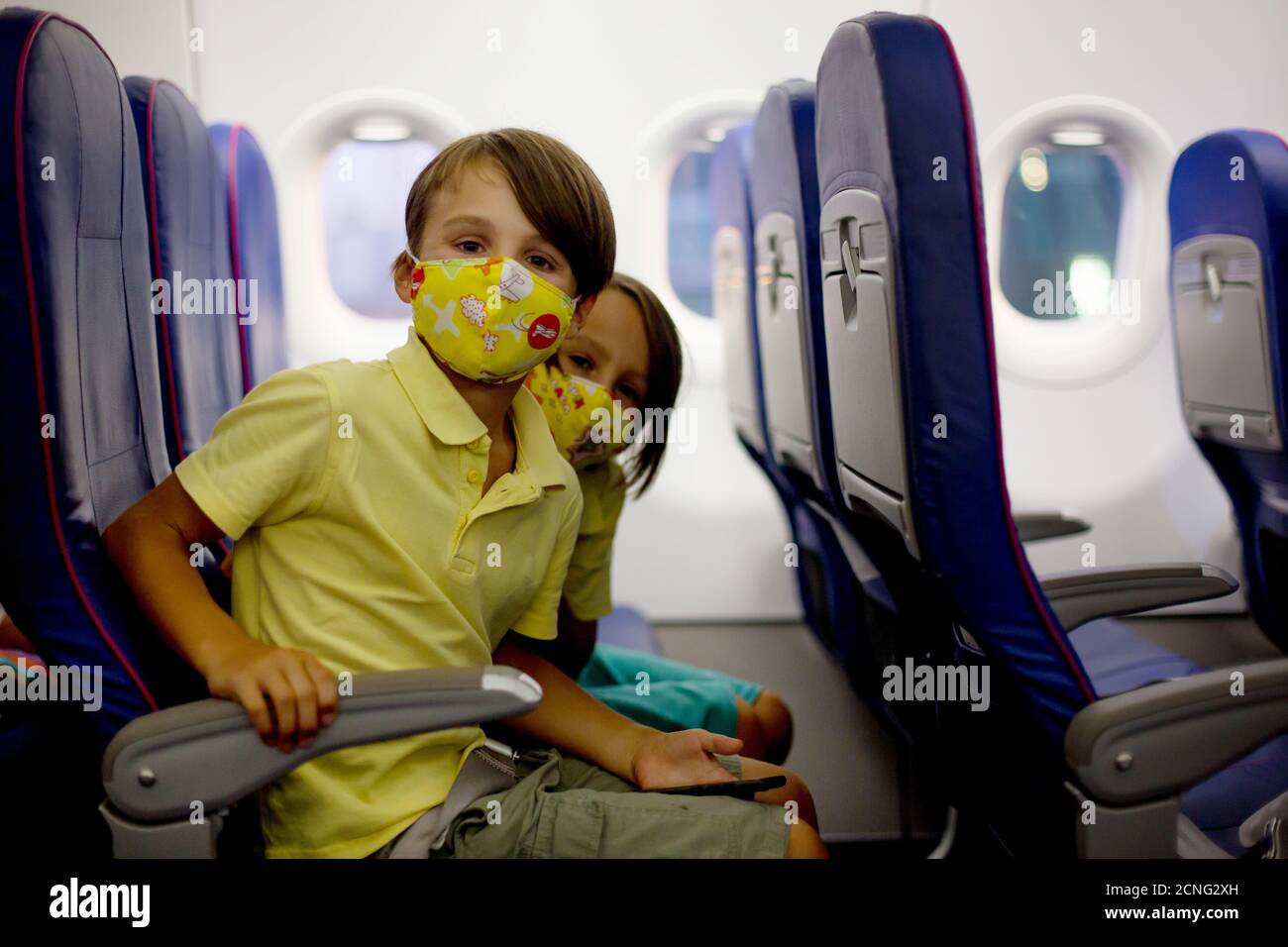 Toddler boy, child boarding on the airplane, sitting and waiting for ...