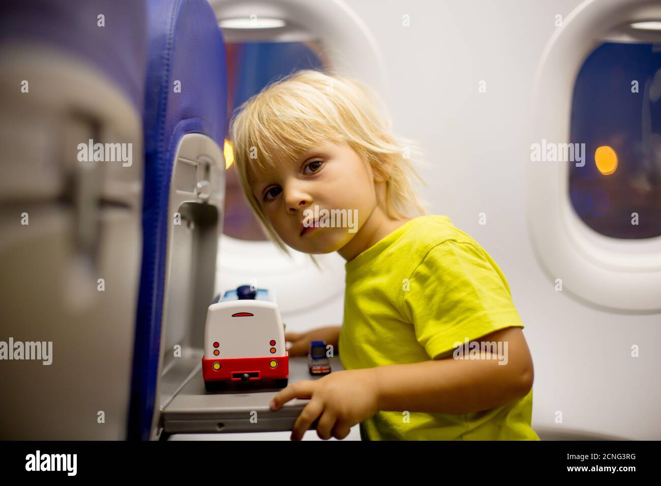 Toddler boy, child boarding on the airplane, sitting and waiting for ...