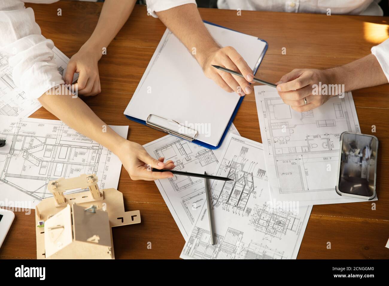 Top view hands of architect-engineer and young couple during ...