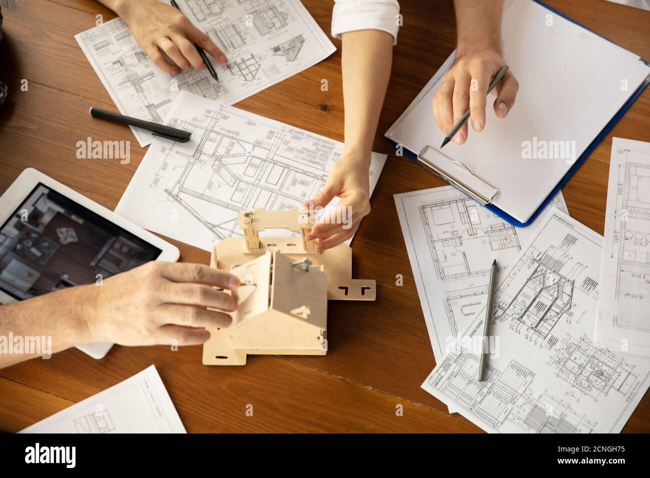 Top view hands of architect-engineer and young couple during ...