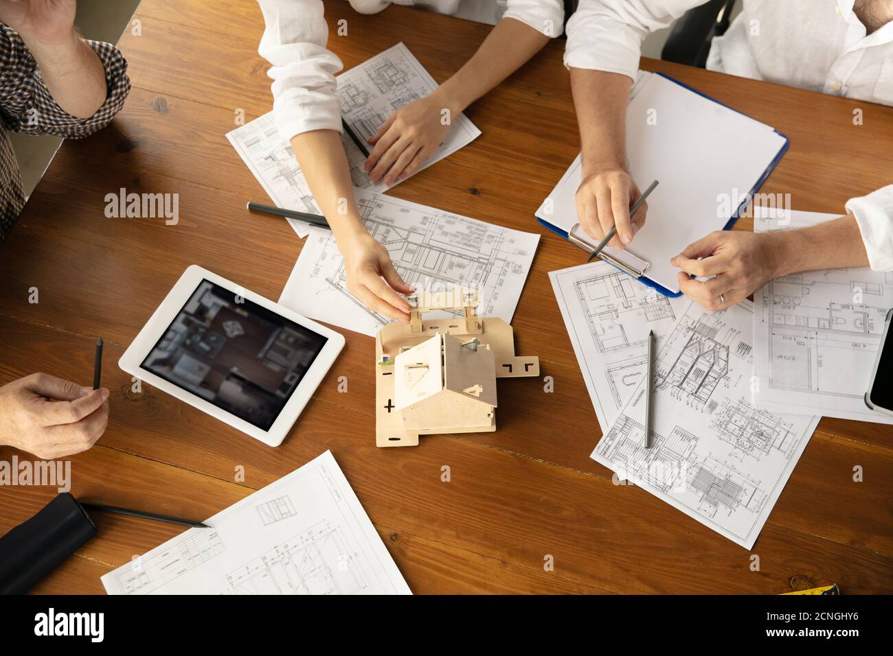 Top view hands of architect-engineer and young couple during ...