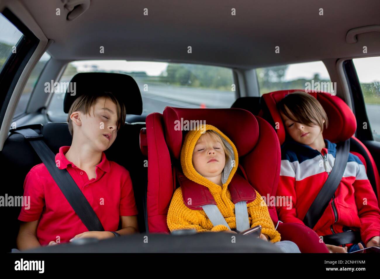 Three children, boys, traveling in car in carseat sleeping tired after ...
