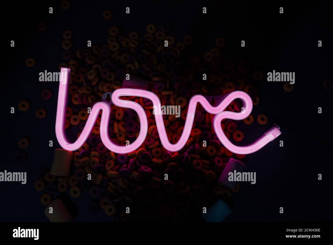 Top view of a neon ''Love'' sign surrounded by marshmallows and ...