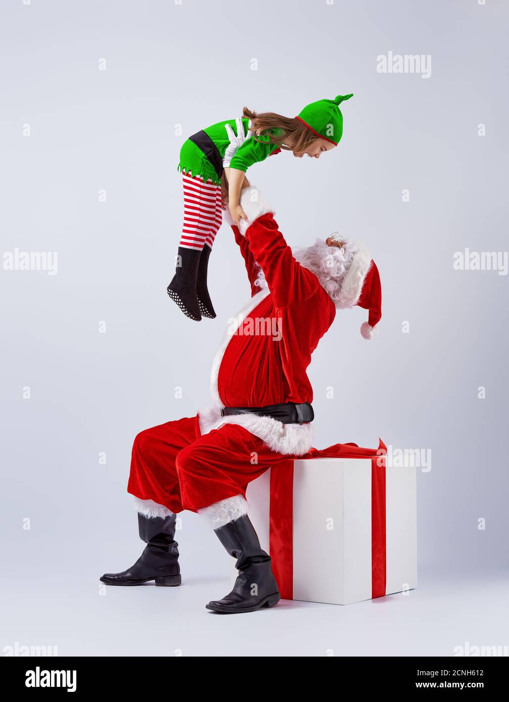 Jolly elf and Santa Claus play together Stock Photo - Alamy