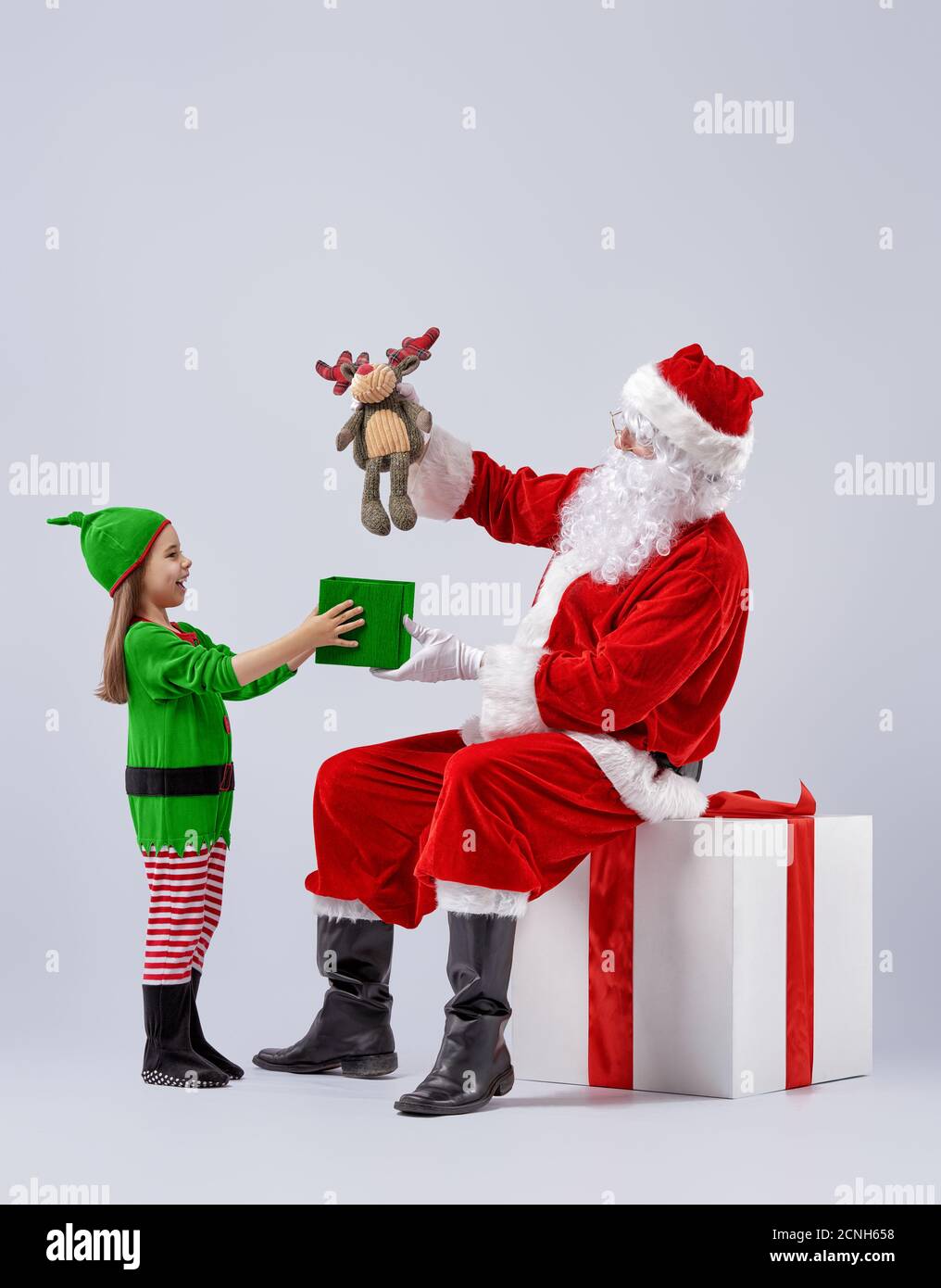 Jolly elf and Santa Claus play together Stock Photo - Alamy