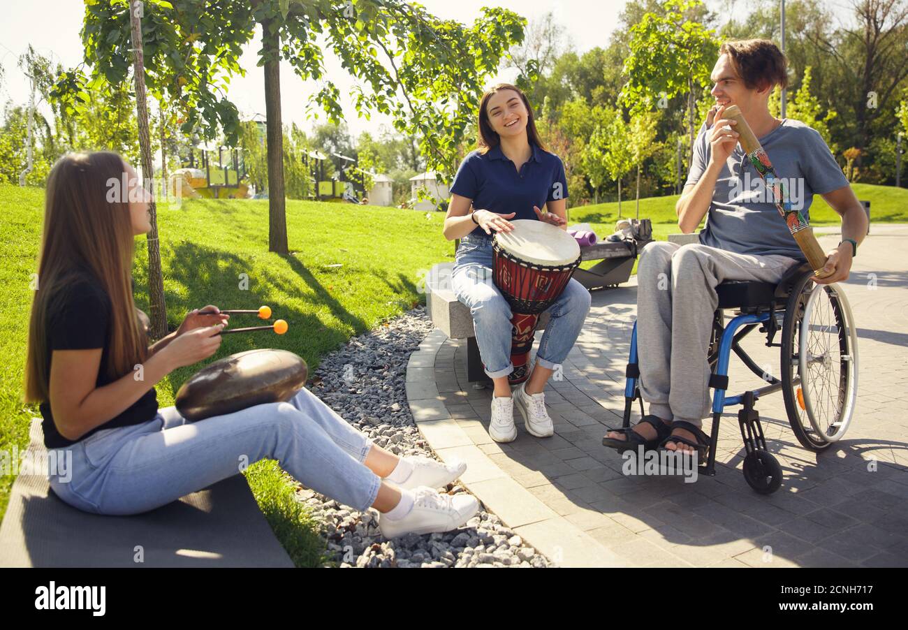 Full life. Happy handicapped man on a wheelchair spending time with ...
