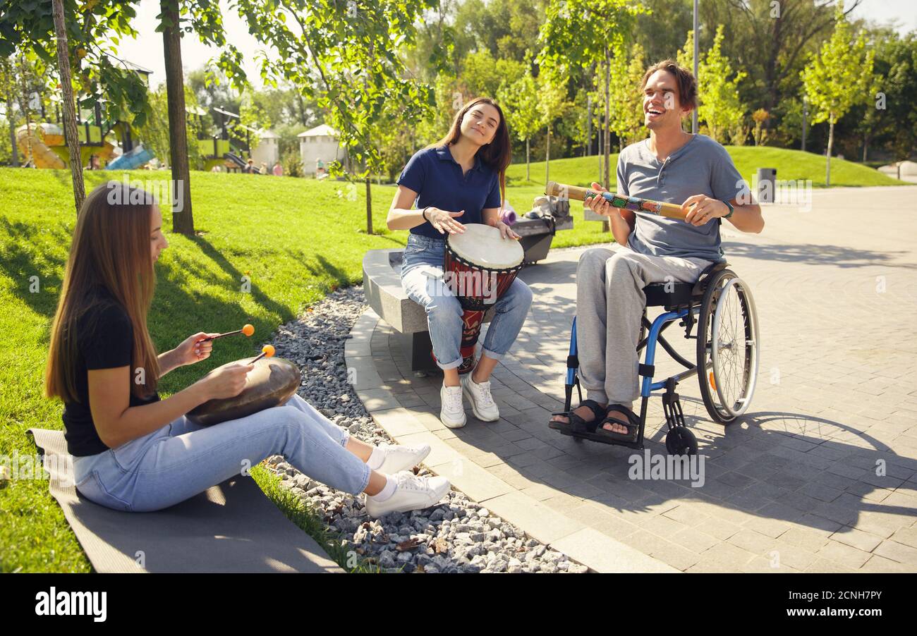 Hobby. Happy handicapped man on a wheelchair spending time with friends ...