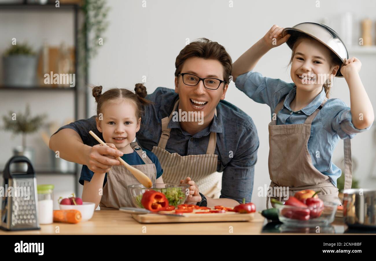 Healthy food at home. Happy family in the kitchen. Father and children ...
