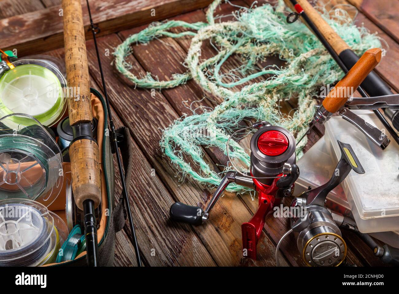 Different fishing tacles with rod and reels on wooden brown background ...
