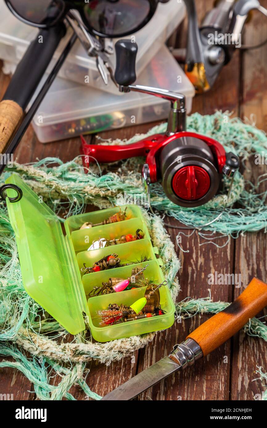 Different fishing tacles with rod and reels on wooden brown background ...