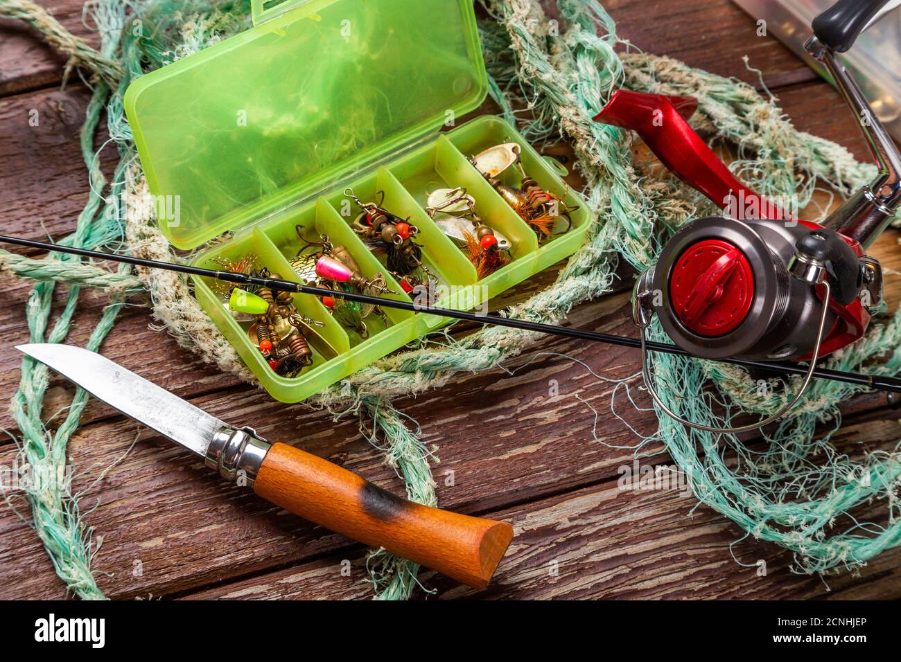 Different fishing tacles with rod and reels on wooden brown background ...