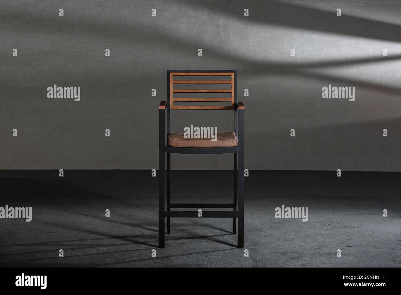 Wooden dining room chair in a studio with gray walls Stock Photo - Alamy