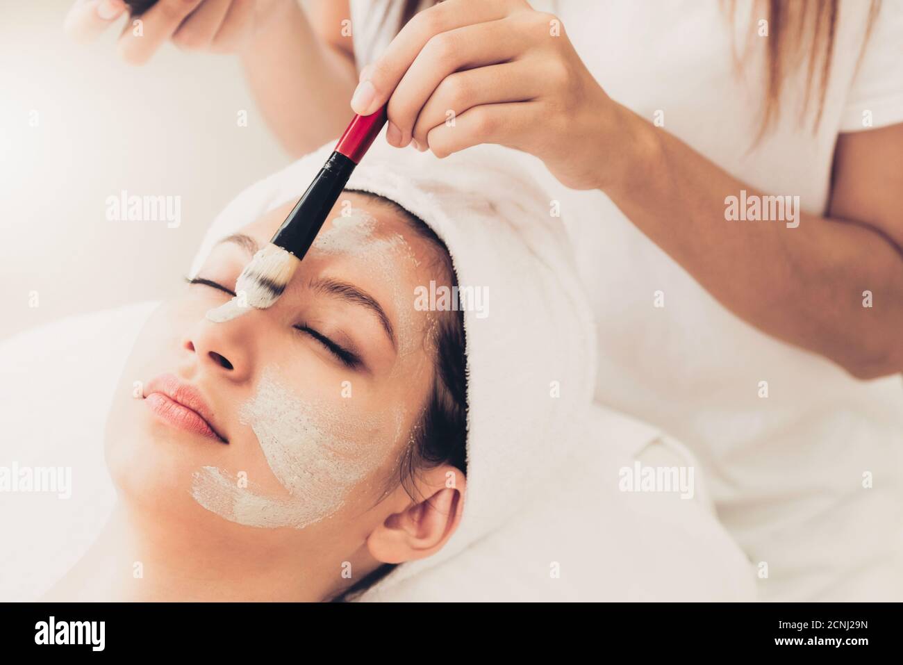 Beautiful woman having a facial cosmetic scrub treatment from ...