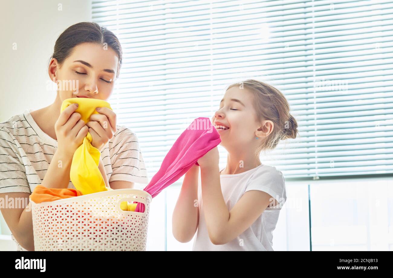 Beautiful young woman and child girl little helper are smelling clean ...