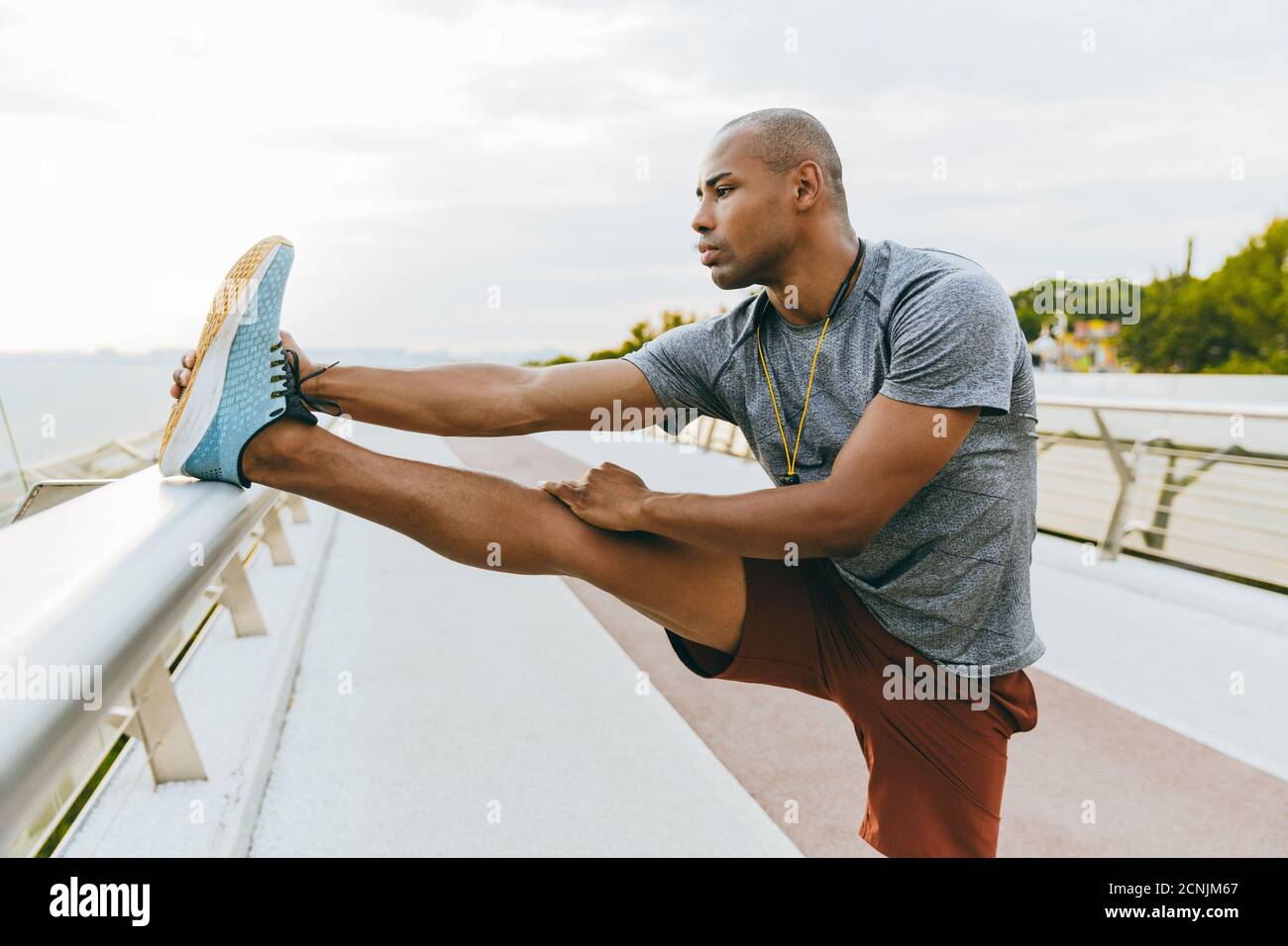 Confident young african sports man stretching on the bridge Stock Photo ...