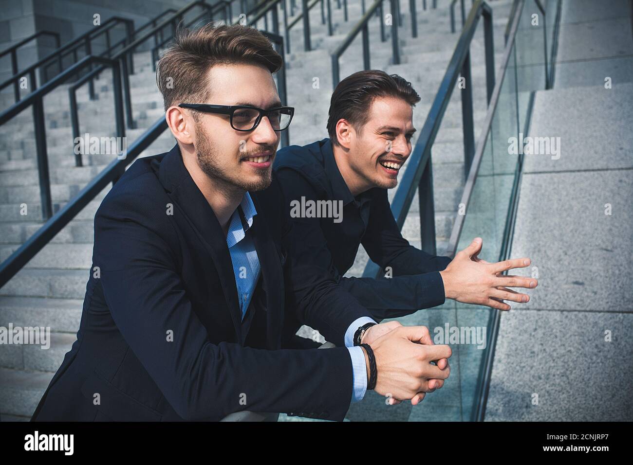 Two smiling colleagues speaking and having fun at street Stock Photo ...