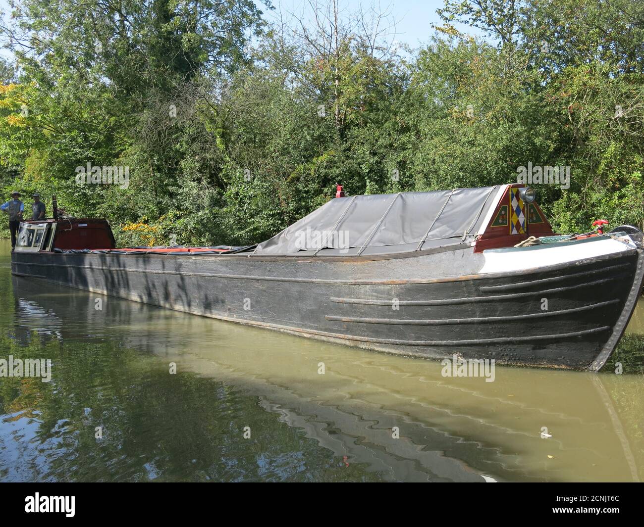 Two men at the stern of a commercial barge travelling along the Grand ...