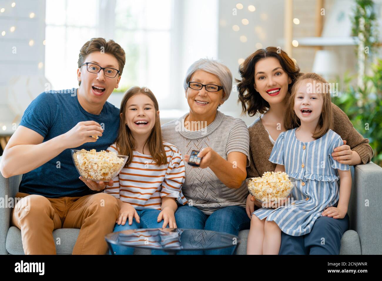 Happy family watching projector, TV, movies with popcorn at home ...