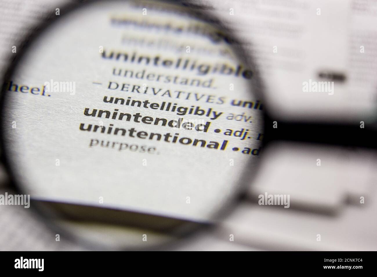 Word or phrase Unintended in a dictionary Stock Photo - Alamy