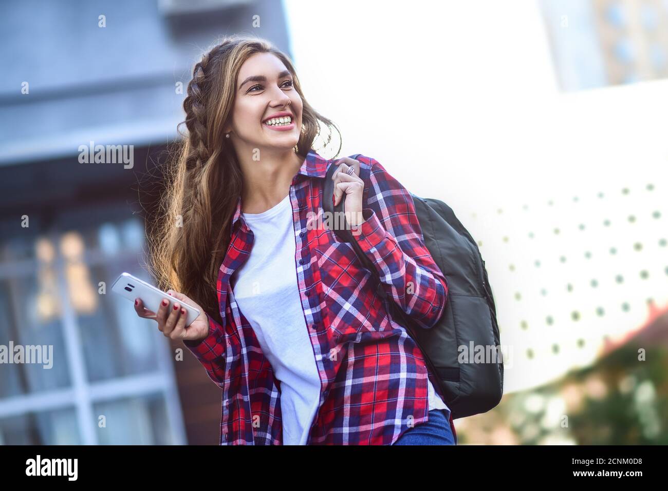 Photo of cute girl walking at street and using a smatphone Stock Photo ...