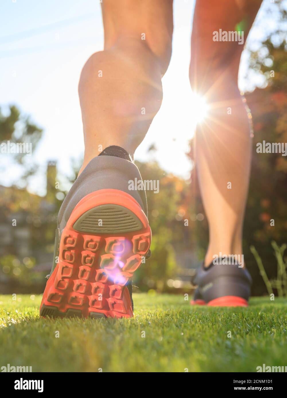 Female athlete runner feet running on the grass, closeup on shoes ...