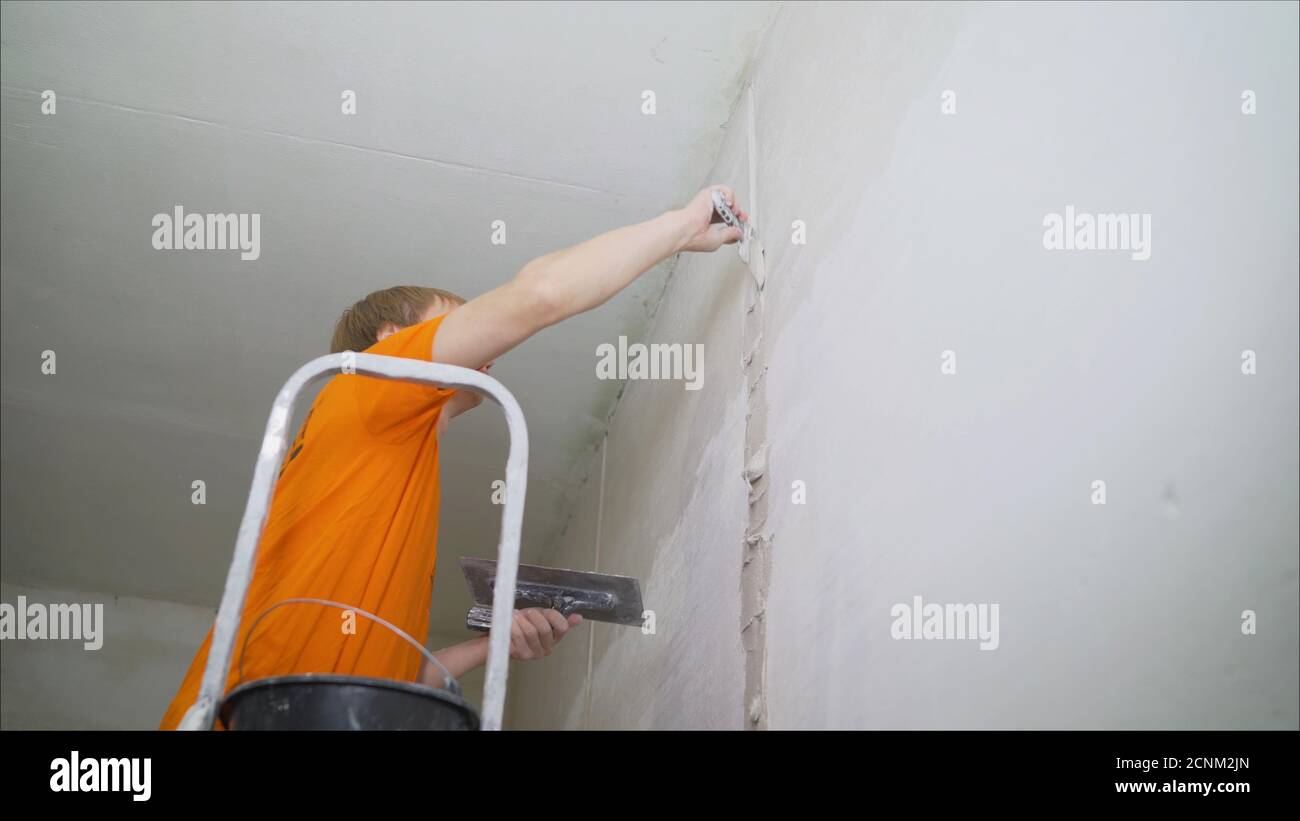Plasterer putting plaster on wall. Worker covers the wall with mortar ...