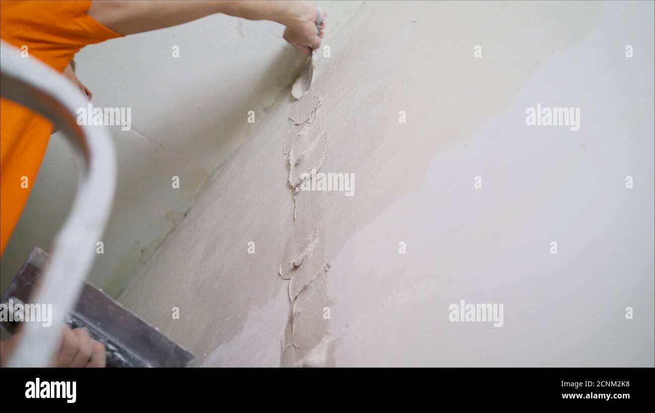 Plasterer putting plaster on wall. Worker covers the wall with mortar ...