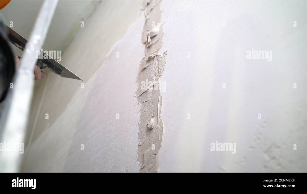Plasterer putting plaster on wall. Worker covers the wall with mortar ...