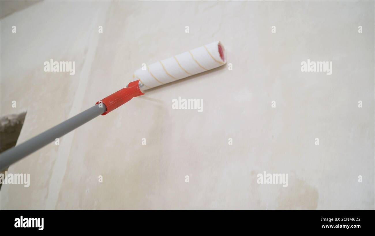 primer on the brick wall with a roller. Brick wall repair with putty ...