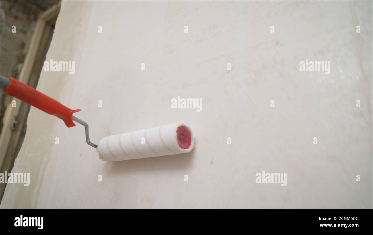 primer on the brick wall with a roller. Brick wall repair with putty ...