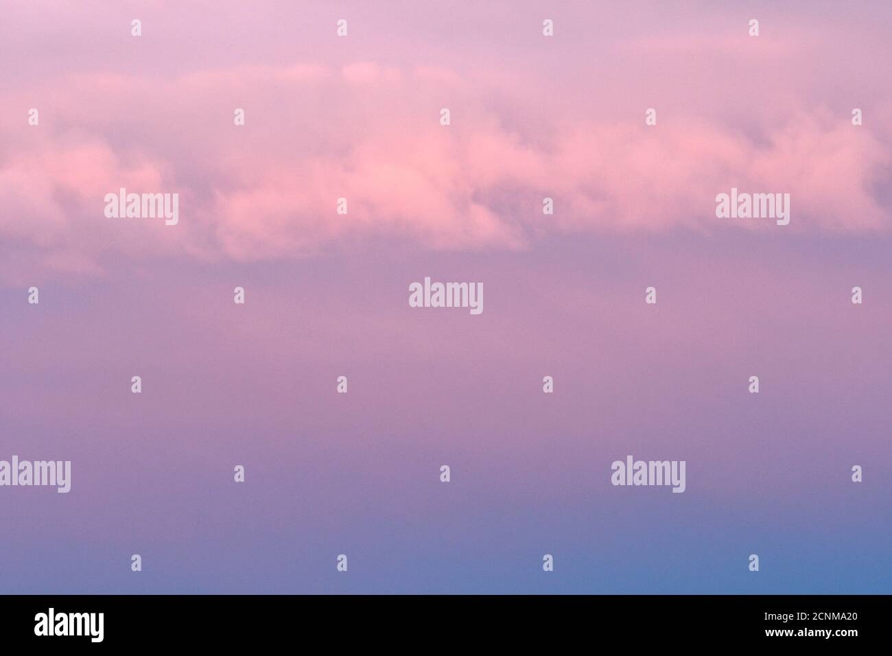 An evening sunset giving the sky and clouds a pink color in rural ...