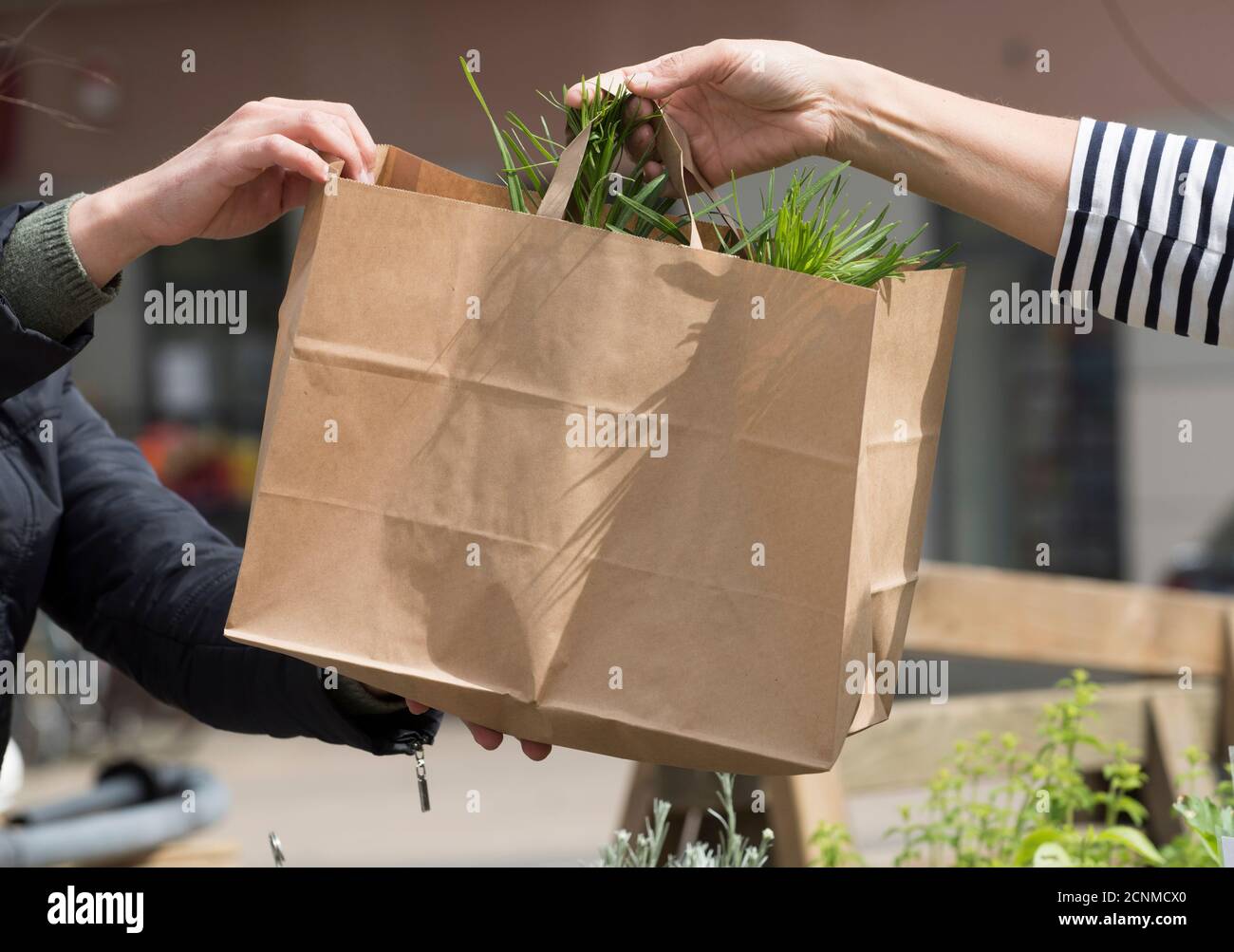 handing over a paper bag for transporting goods at the market Stock ...