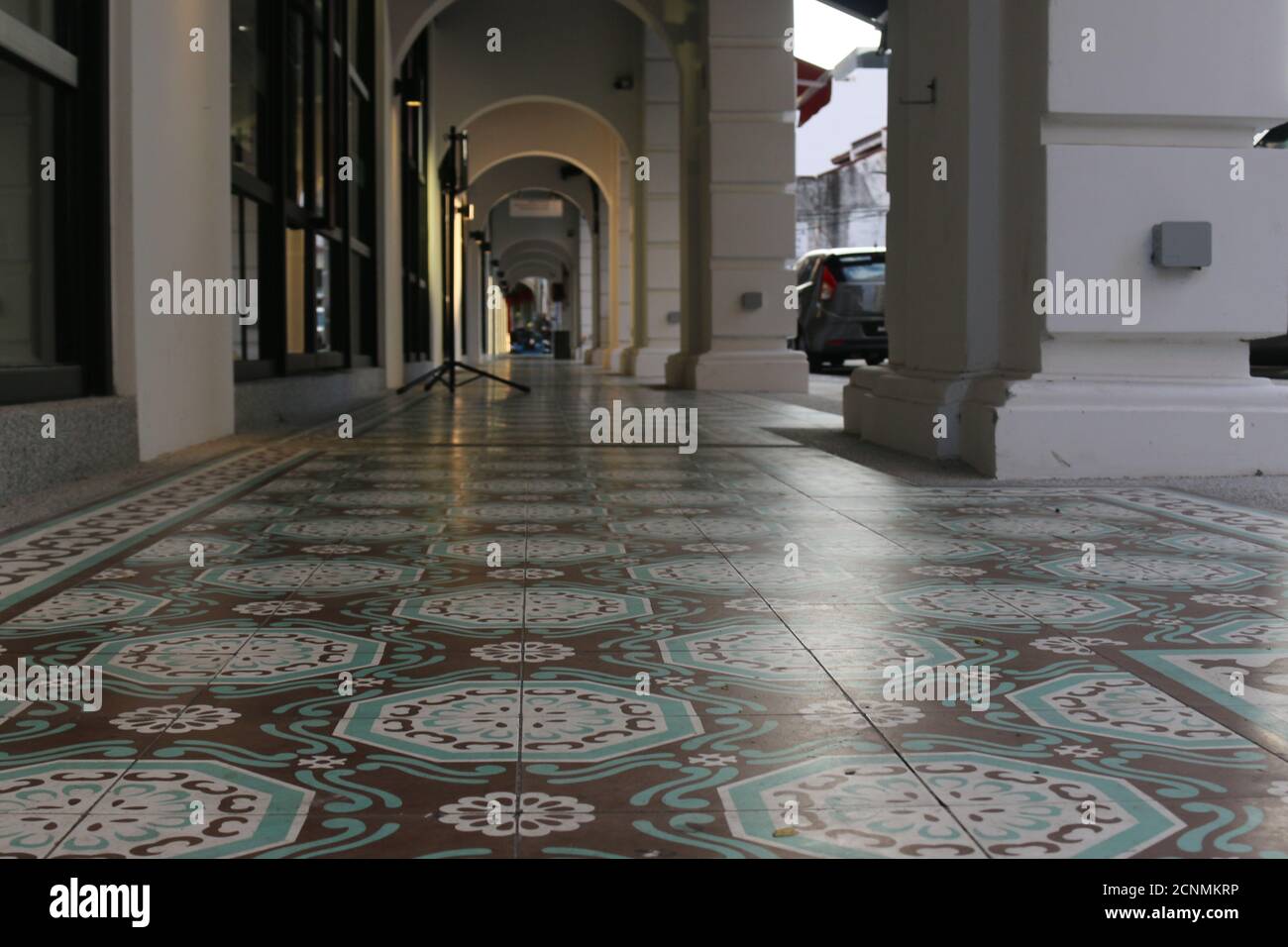 View through an archway with white facade, windows and decorative floor ...