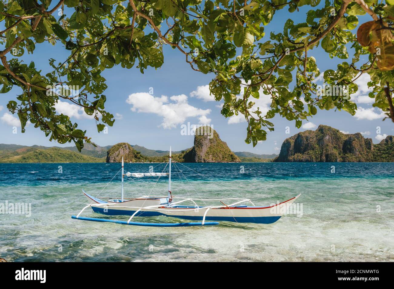 Banca boat in shallow blue water on Ipil beach of Pinagbuyutan Island ...