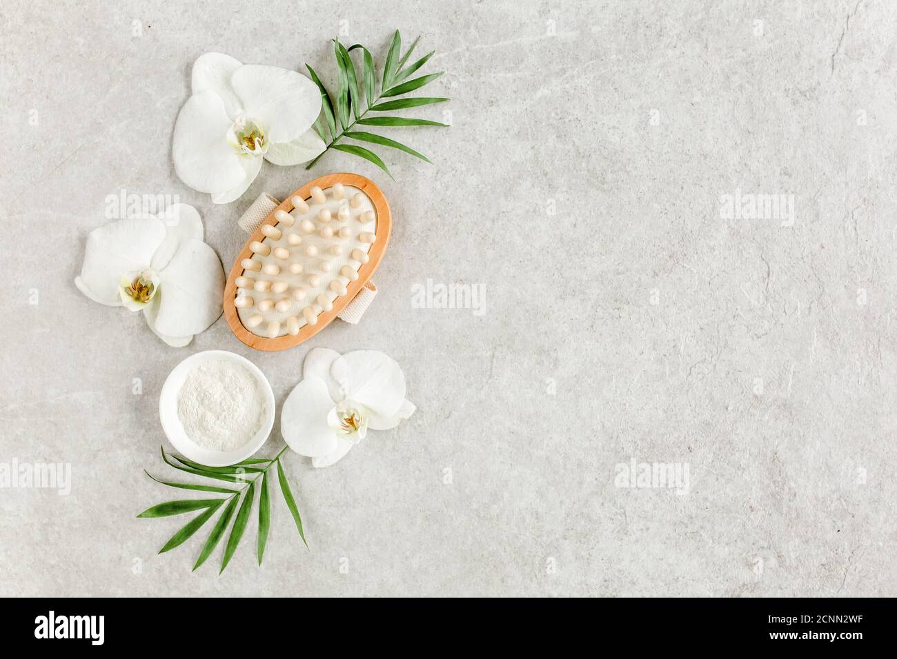Spa treatment concept. Natural spa cosmetics products, sea salt, massage brush, tropic palm ...