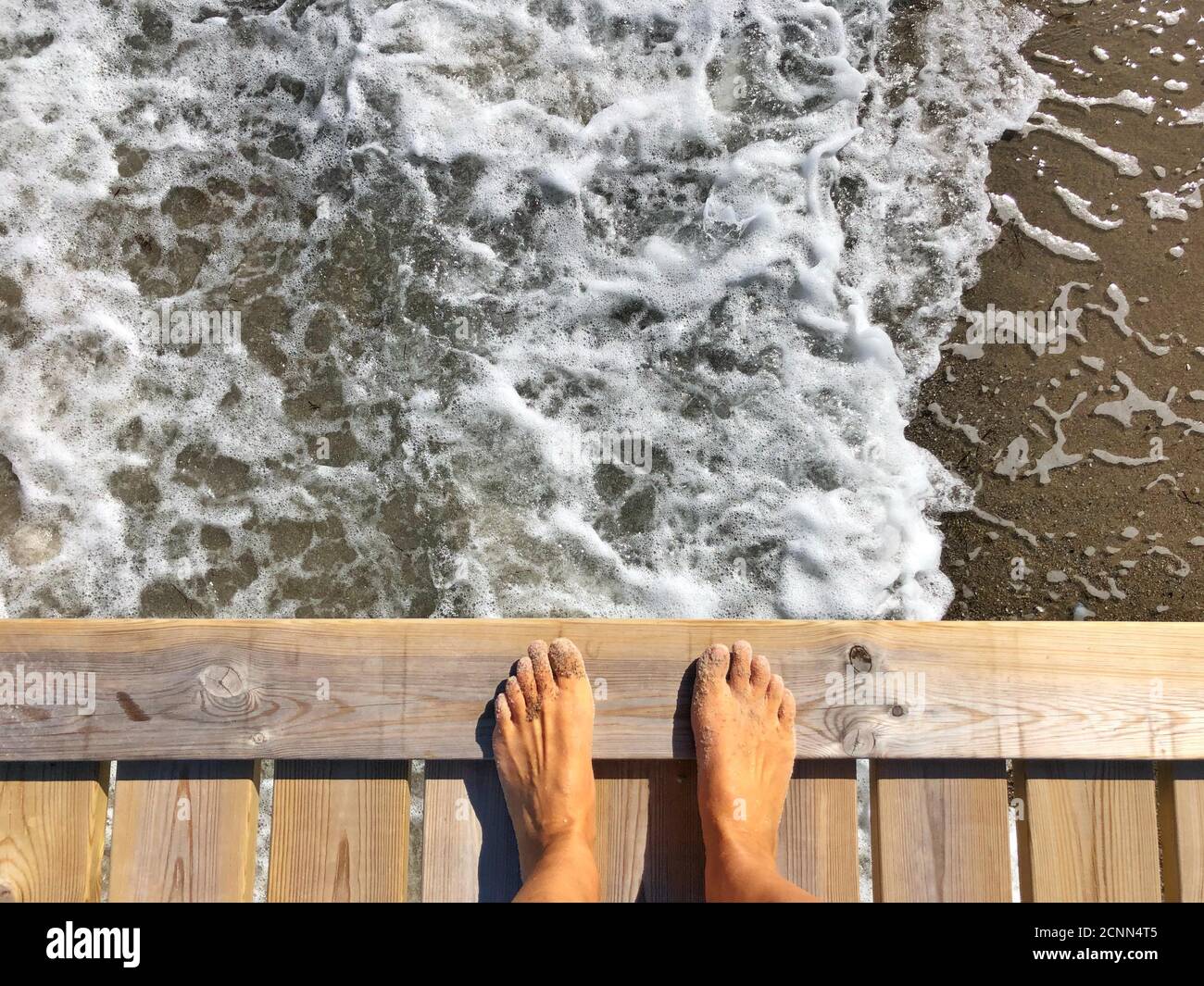 Barefoot woman standing on a wooden jetty, Nordby, Samsoe, Denmark ...