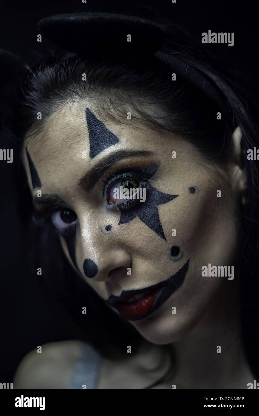Vertical shot of a female with scary killer clown makeup to celebrate ...