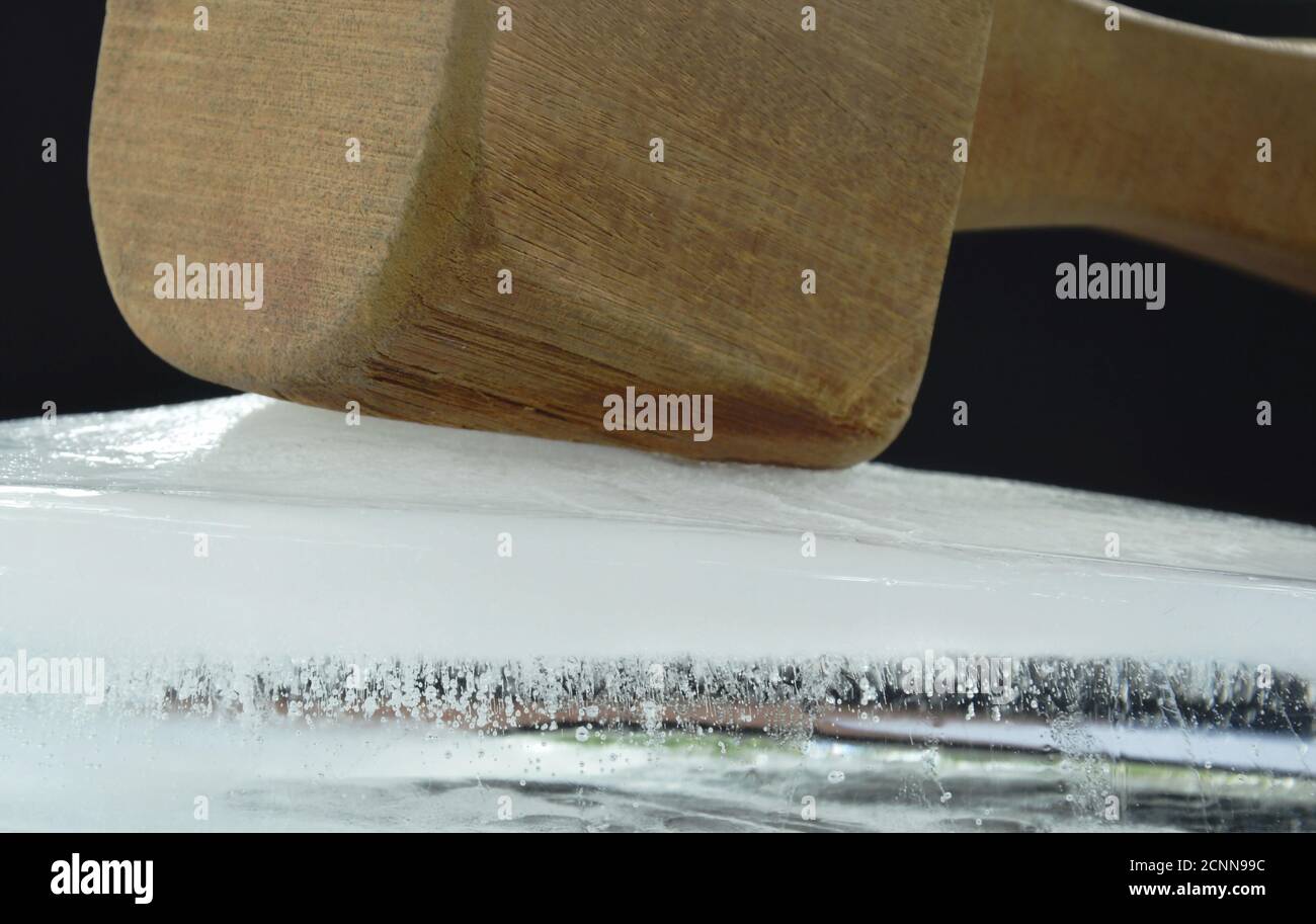 Big and heavy wooden hammer smashed ice brick on black background Stock ...
