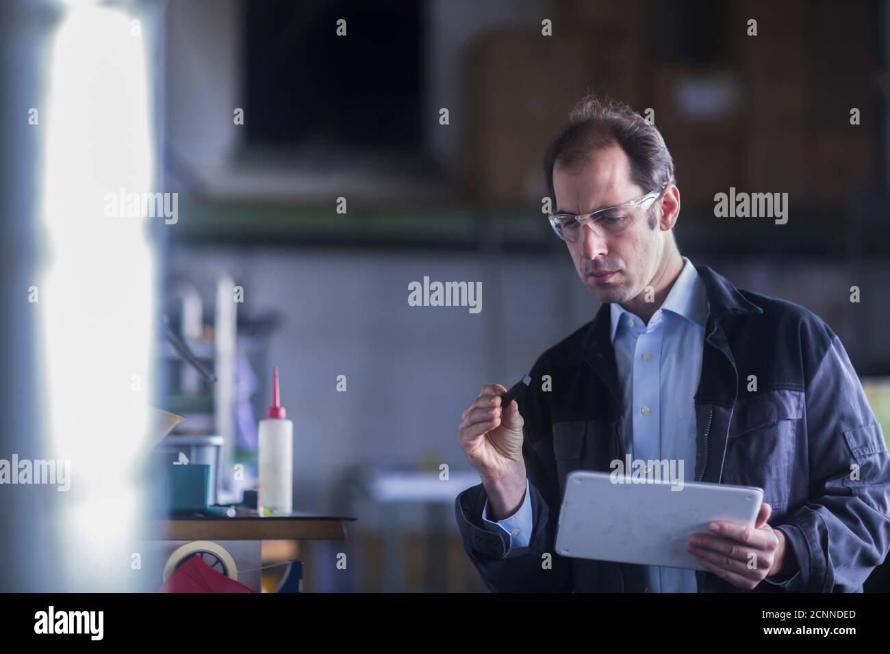 Engineer inspecting a machine part in an industrial plant, Germany ...
