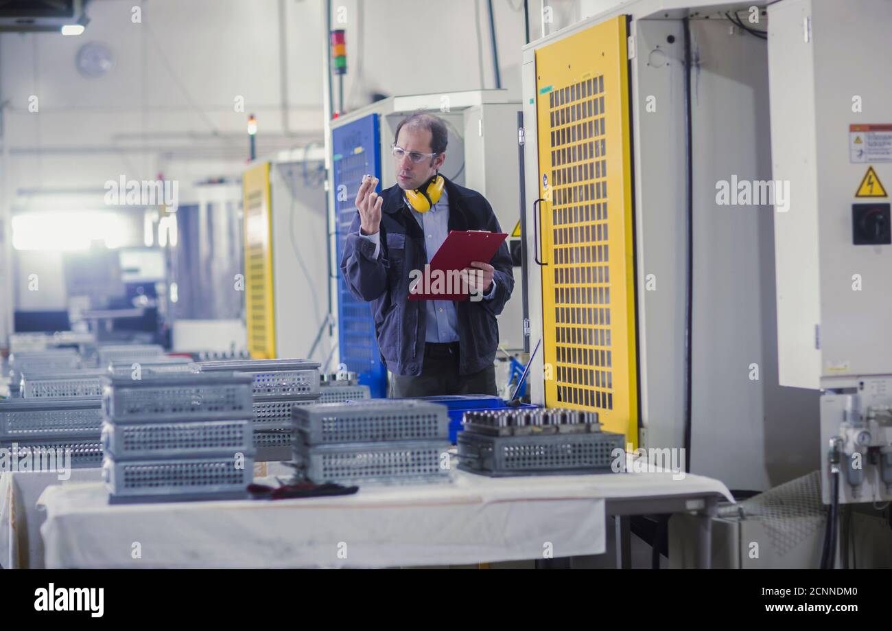 Engineer inspecting a machine part in an industrial plant, Germany ...