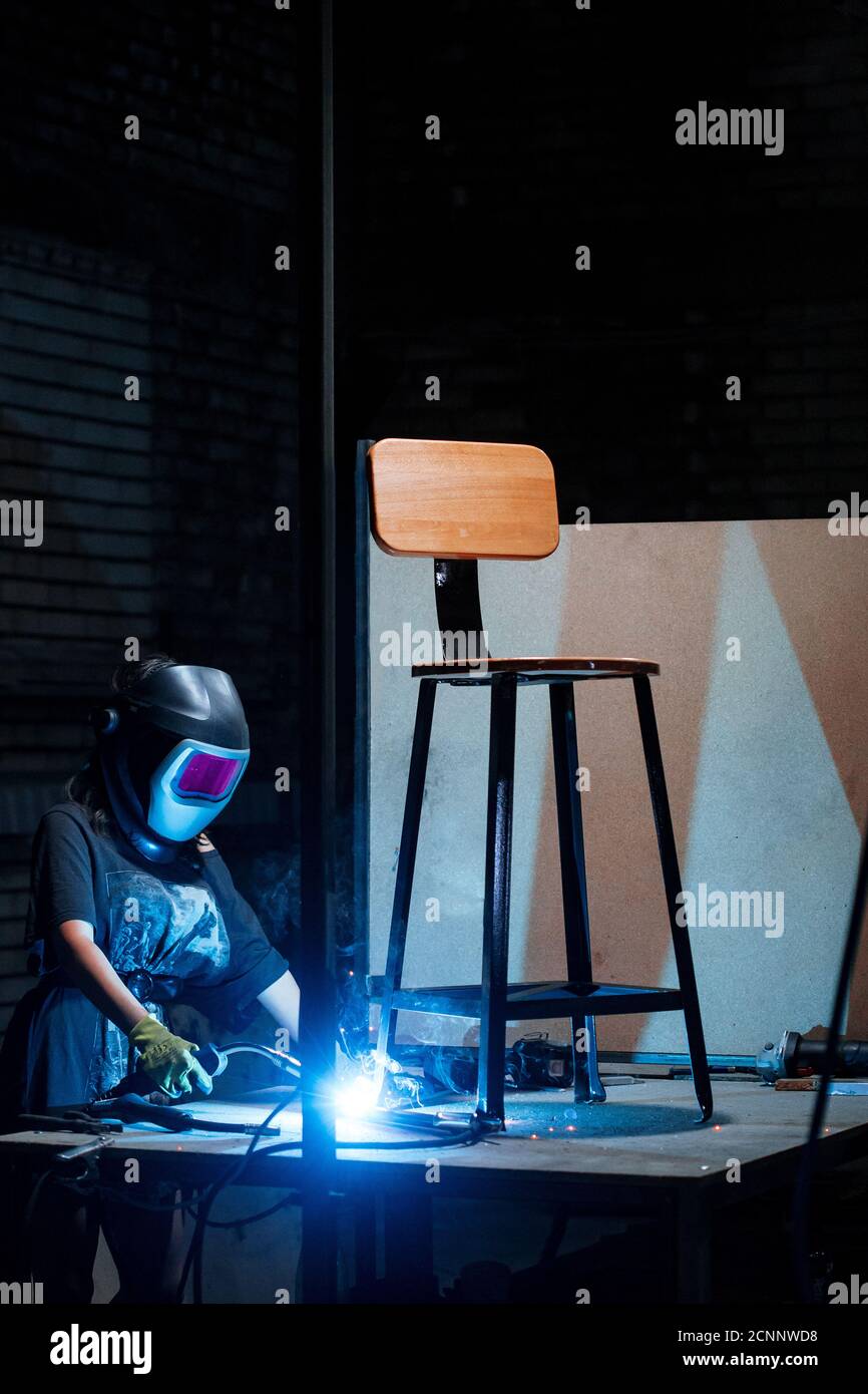 Vertical shot of a female worker welding the legs of a stool Stock ...