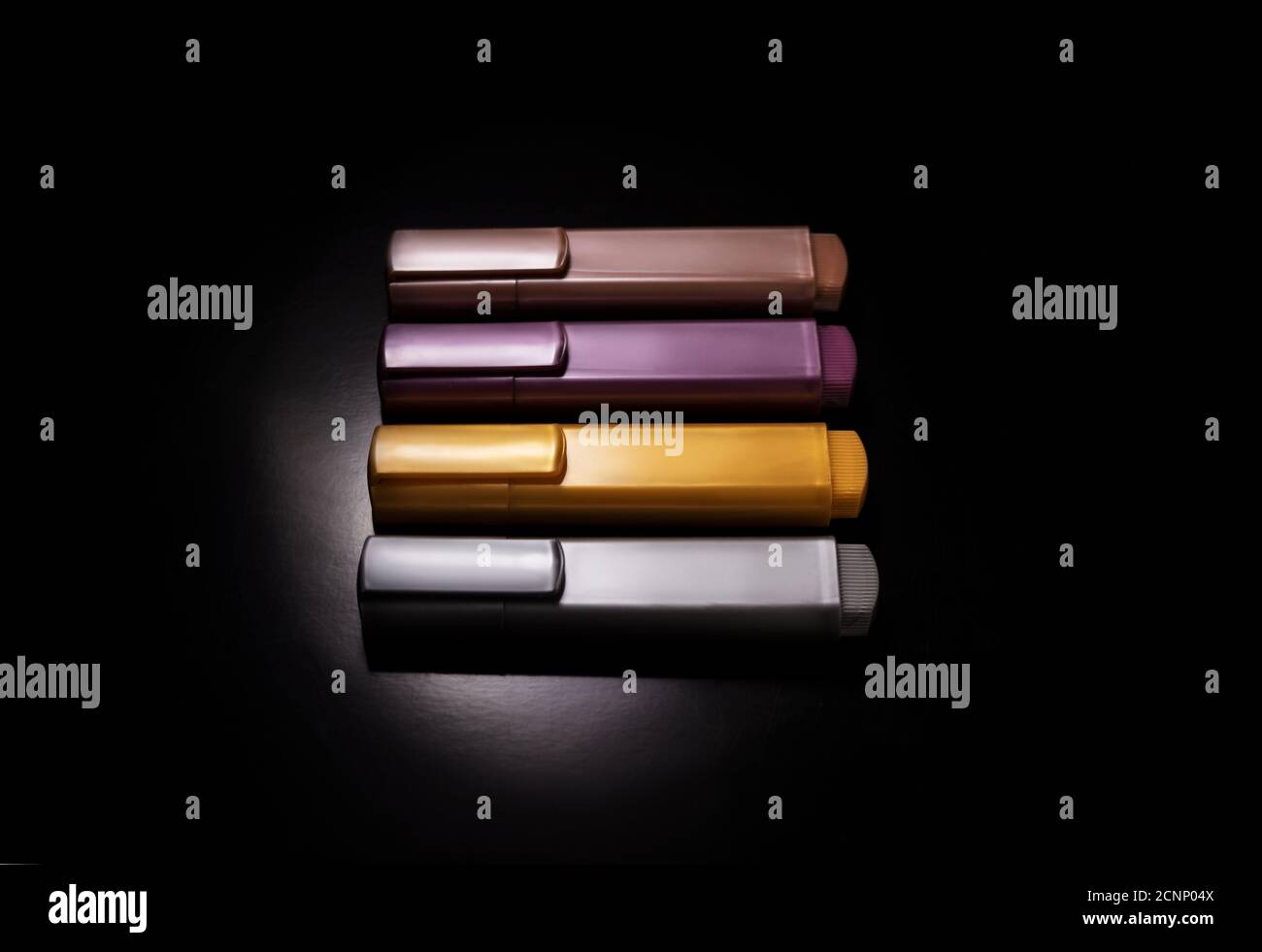 Set of colored markers (silver, gold, ruby and pearl rose) on black ...