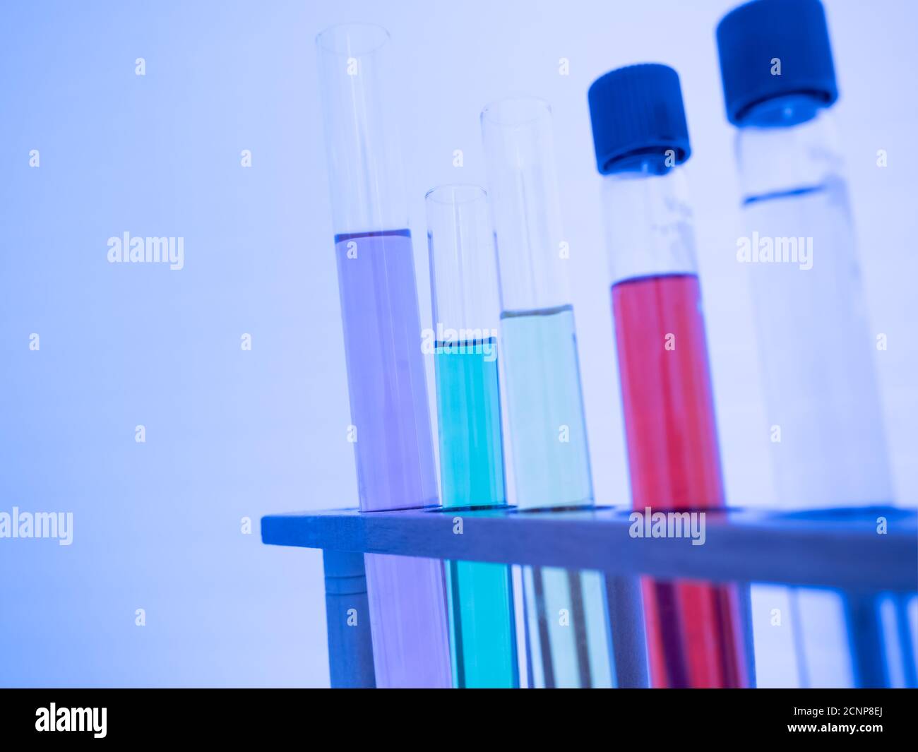 The test tube has a multicolored liquid inside. Put on a table for ...