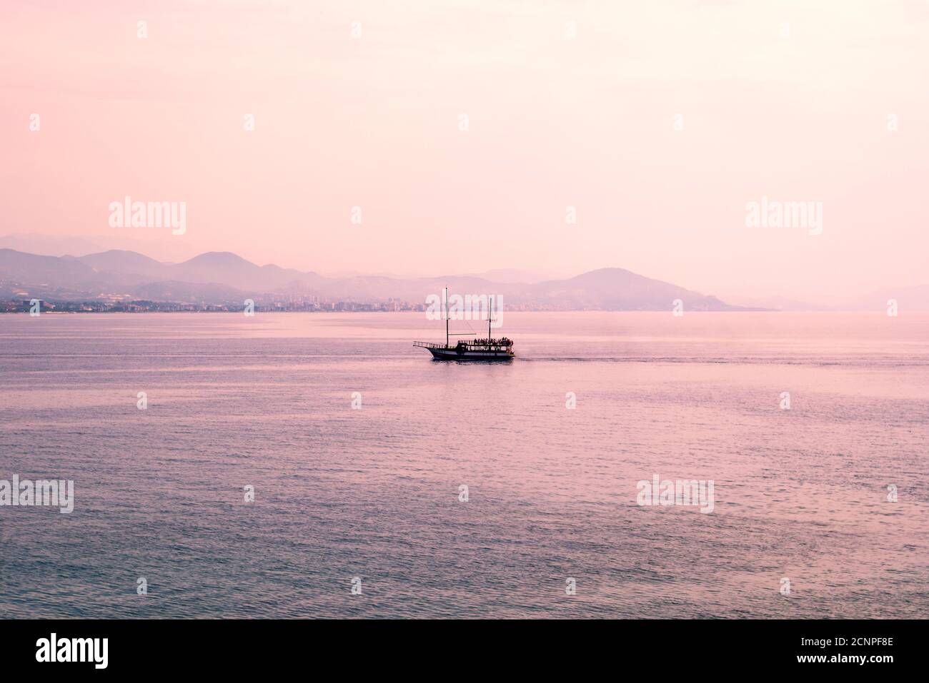 Excursion ship sailing late in the afternoon with setting sun in ...