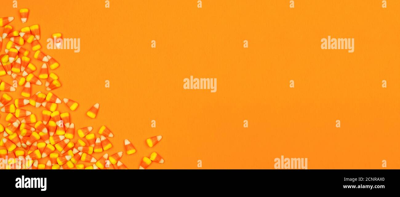 Halloween candy corn corner border banner. Top view against an orange ...
