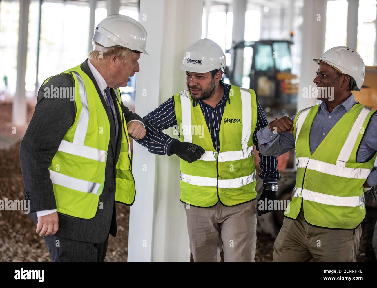 Prime Minister Boris Johnson bumps elbows with construction workers as ...