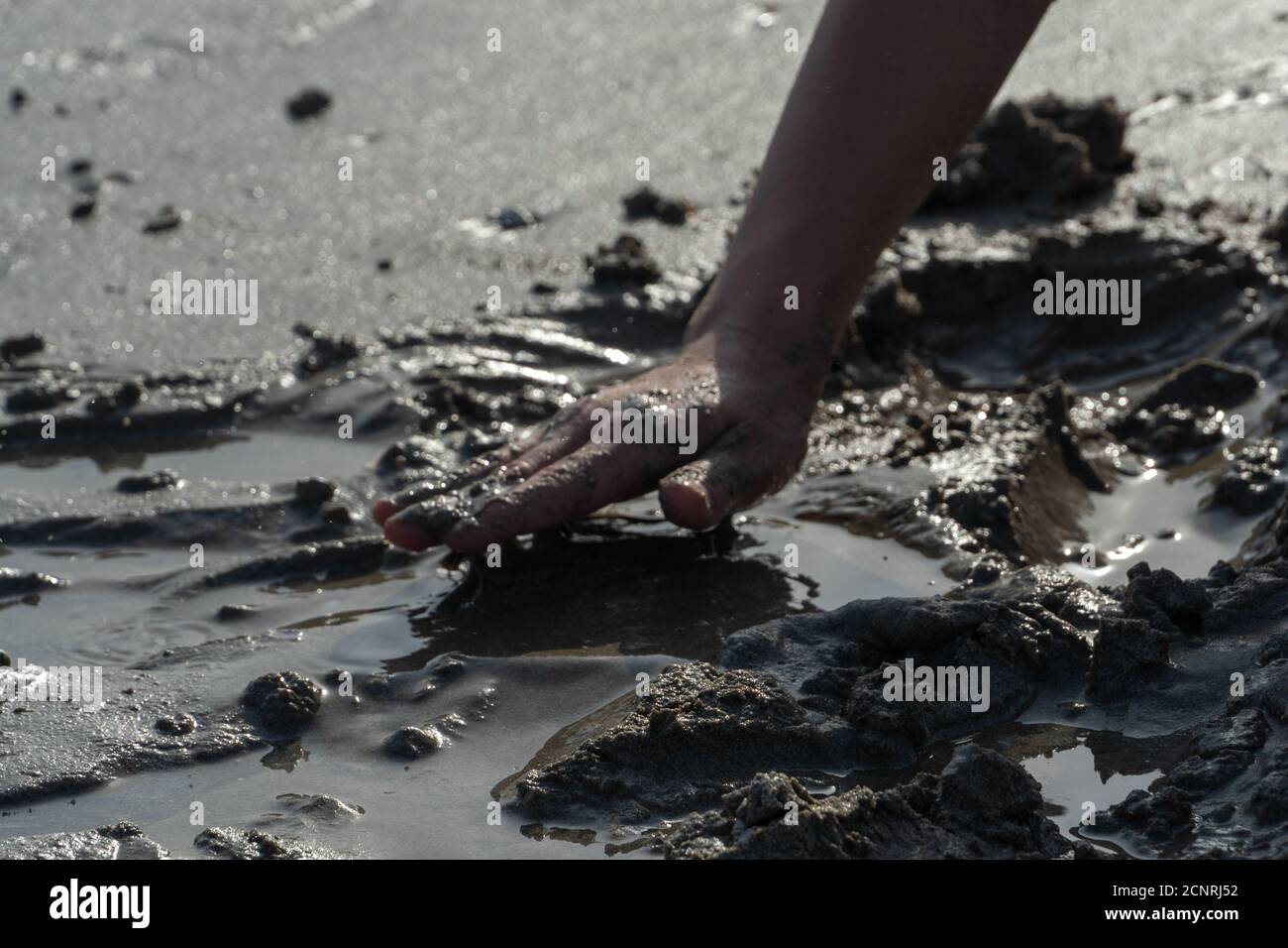 Childs hand in mud hi-res stock photography and images - Alamy