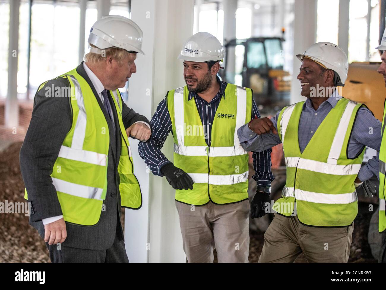 Prime Minister Boris Johnson bumps elbows with construction workers as ...