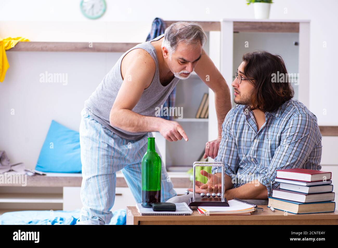 Young son student and dad alcoholic at home Stock Photo - Alamy