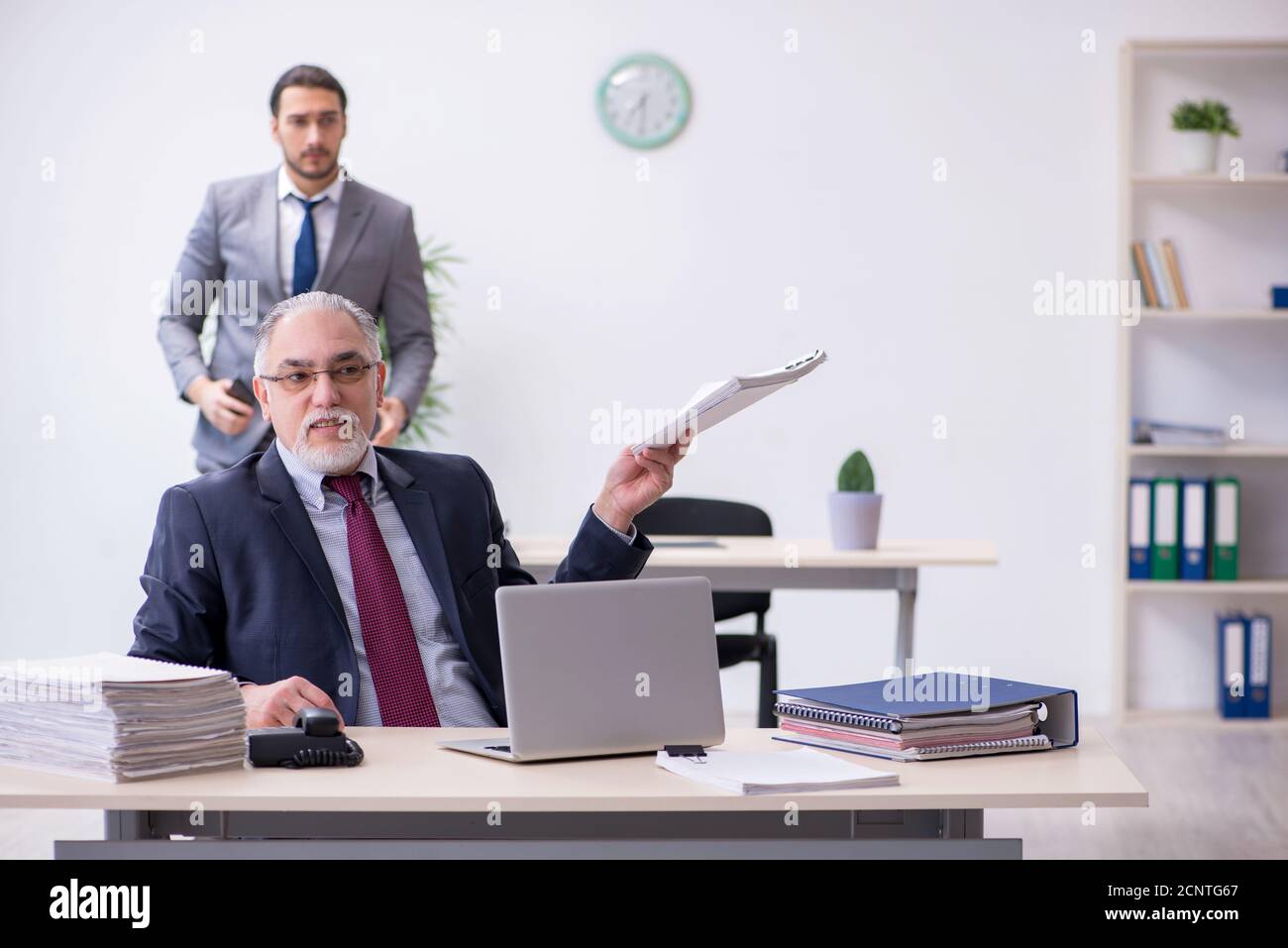Old boss and his assistant working in the office Stock Photo - Alamy